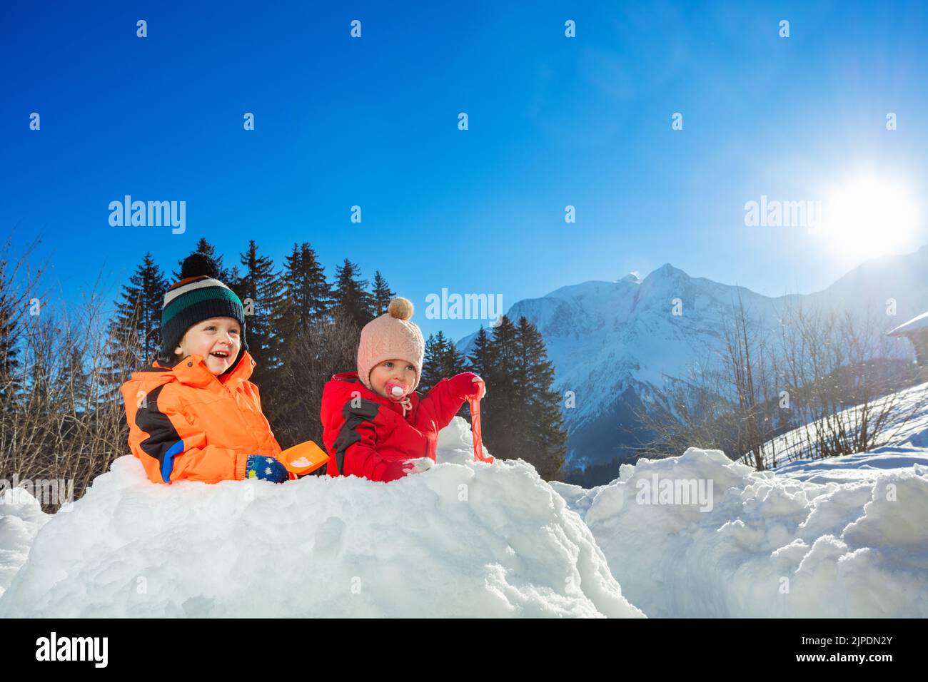Little boy with baby girl stand in the snow fortress Stock Photo - Alamy