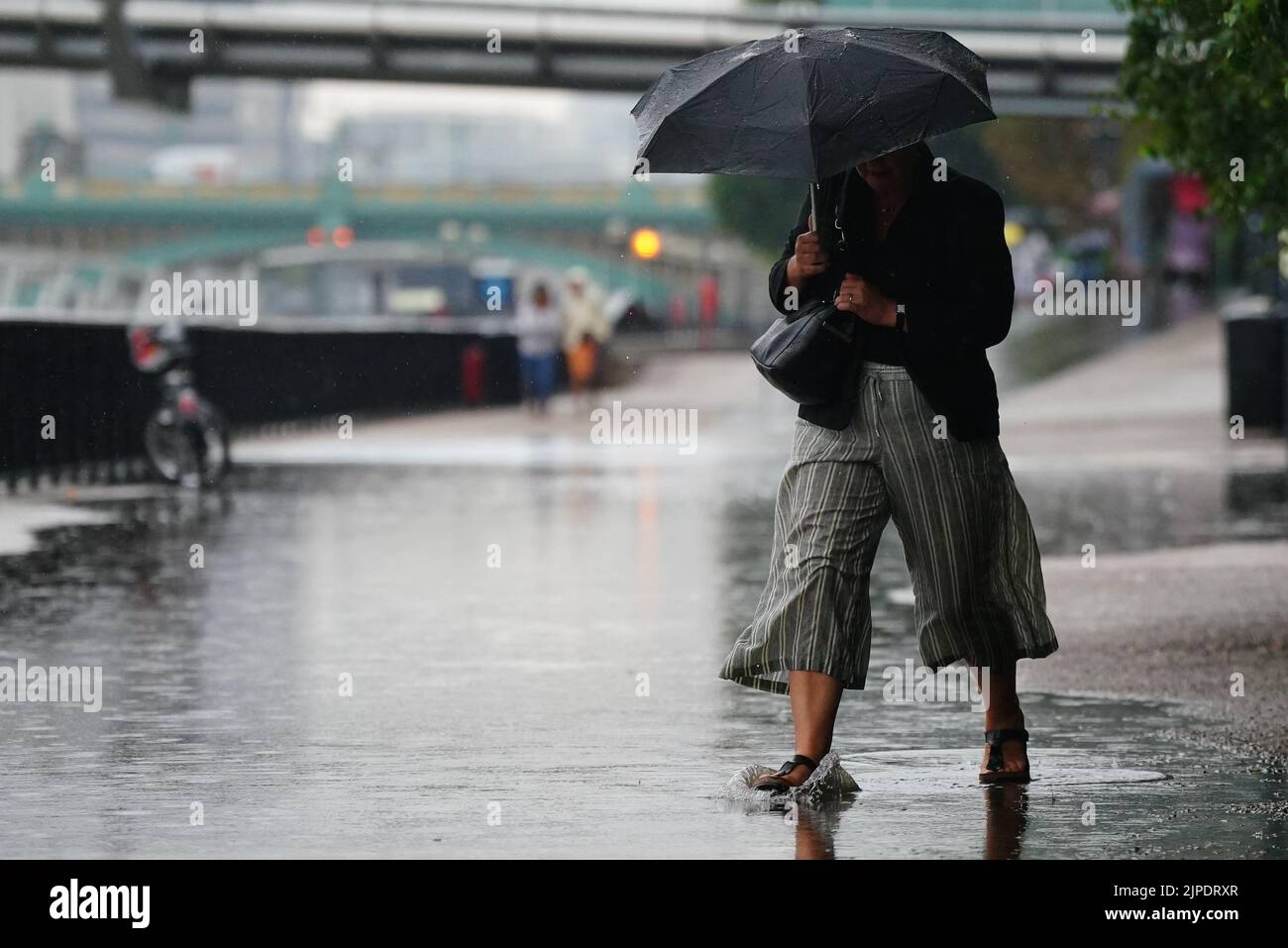 People walking in the rain in London. After weeks of sweltering weather ...