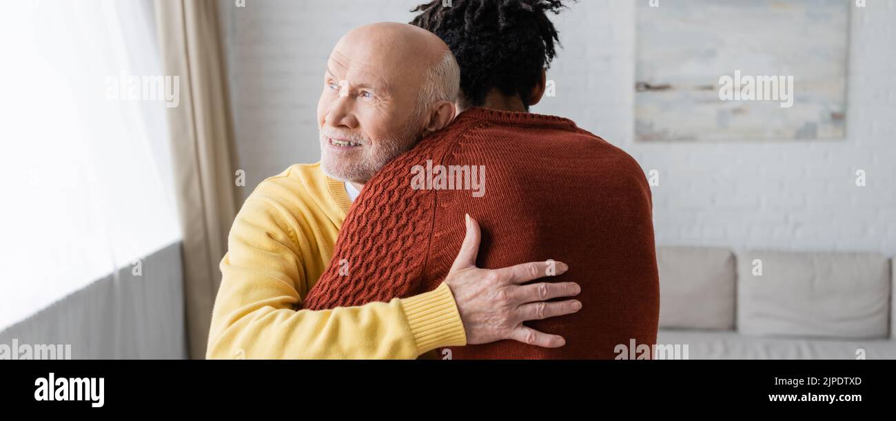 Positive grandparent hugging african american grandson at home, banner ...