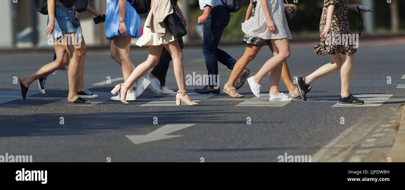 A crowd of pedestrians crossing street in the city, people walking in ...
