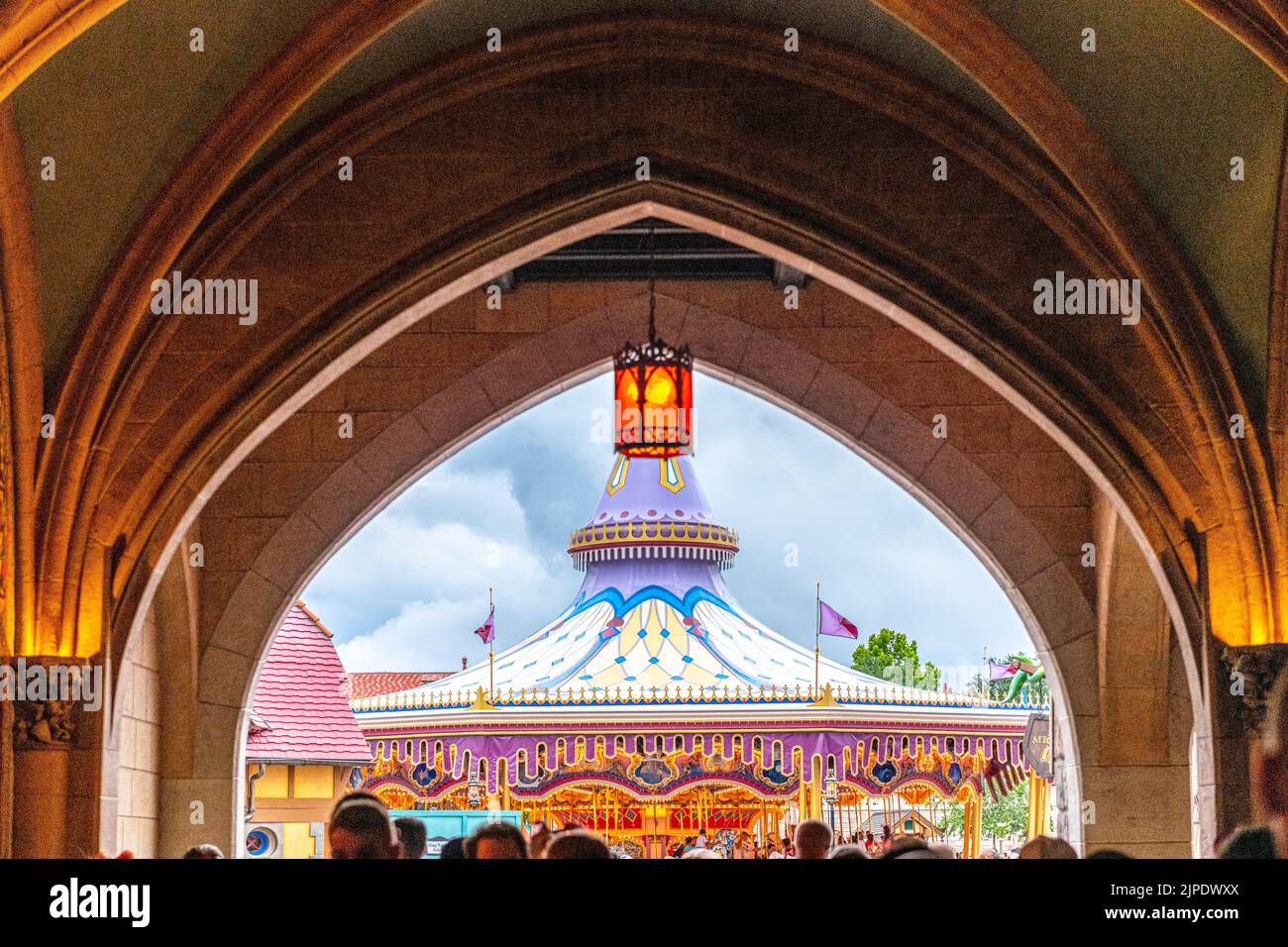 The carousel amusement park ride framed in arches of a building Stock ...