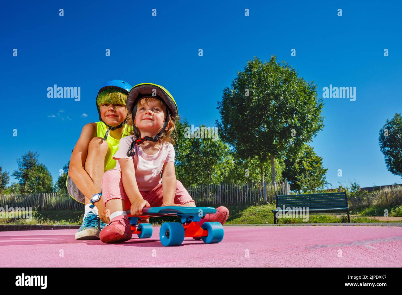 Big brother play with little sister push skate at the park Stock Photo ...