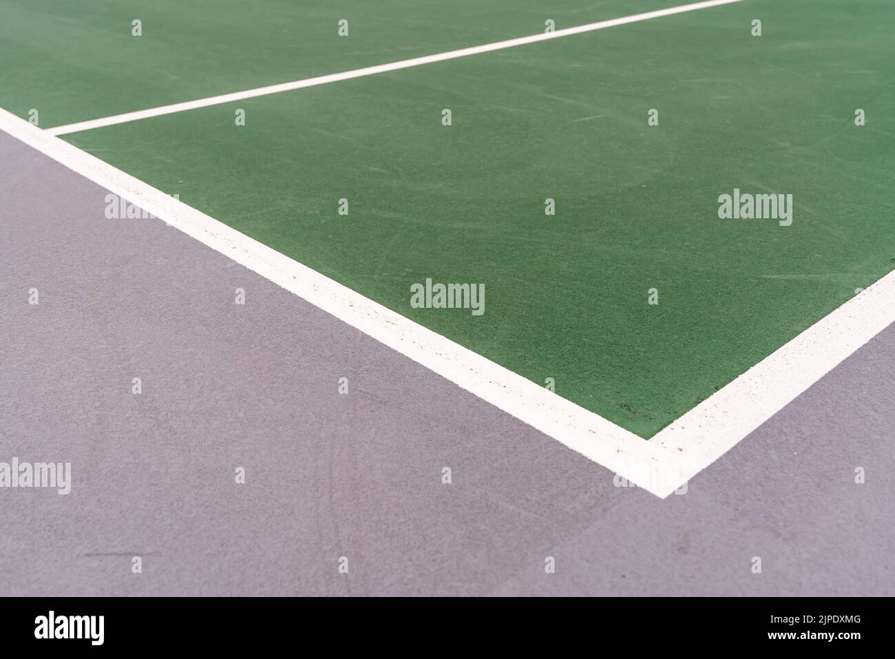 New outdoor green tennis courts with white lines and gray out of bounds ...