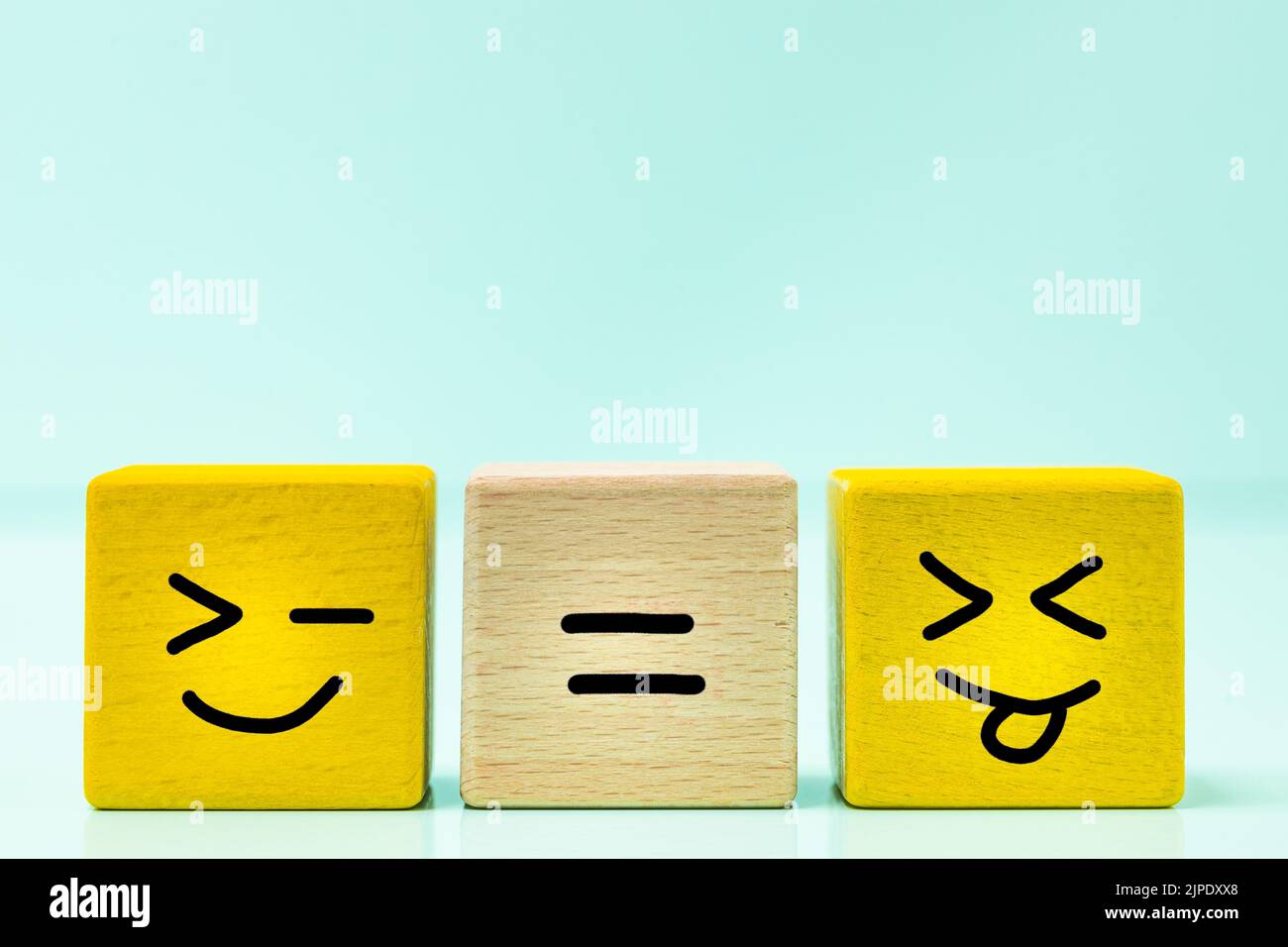 Positive balance, wooden blocks with a hand drawn smile, an equal sign ...