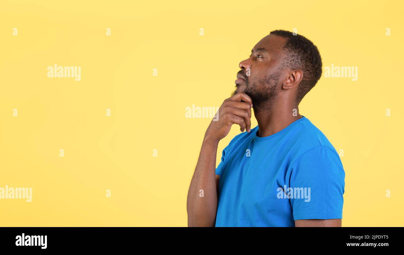 Side View Of Black Man Thinking Standing Over Yellow Background Stock ...