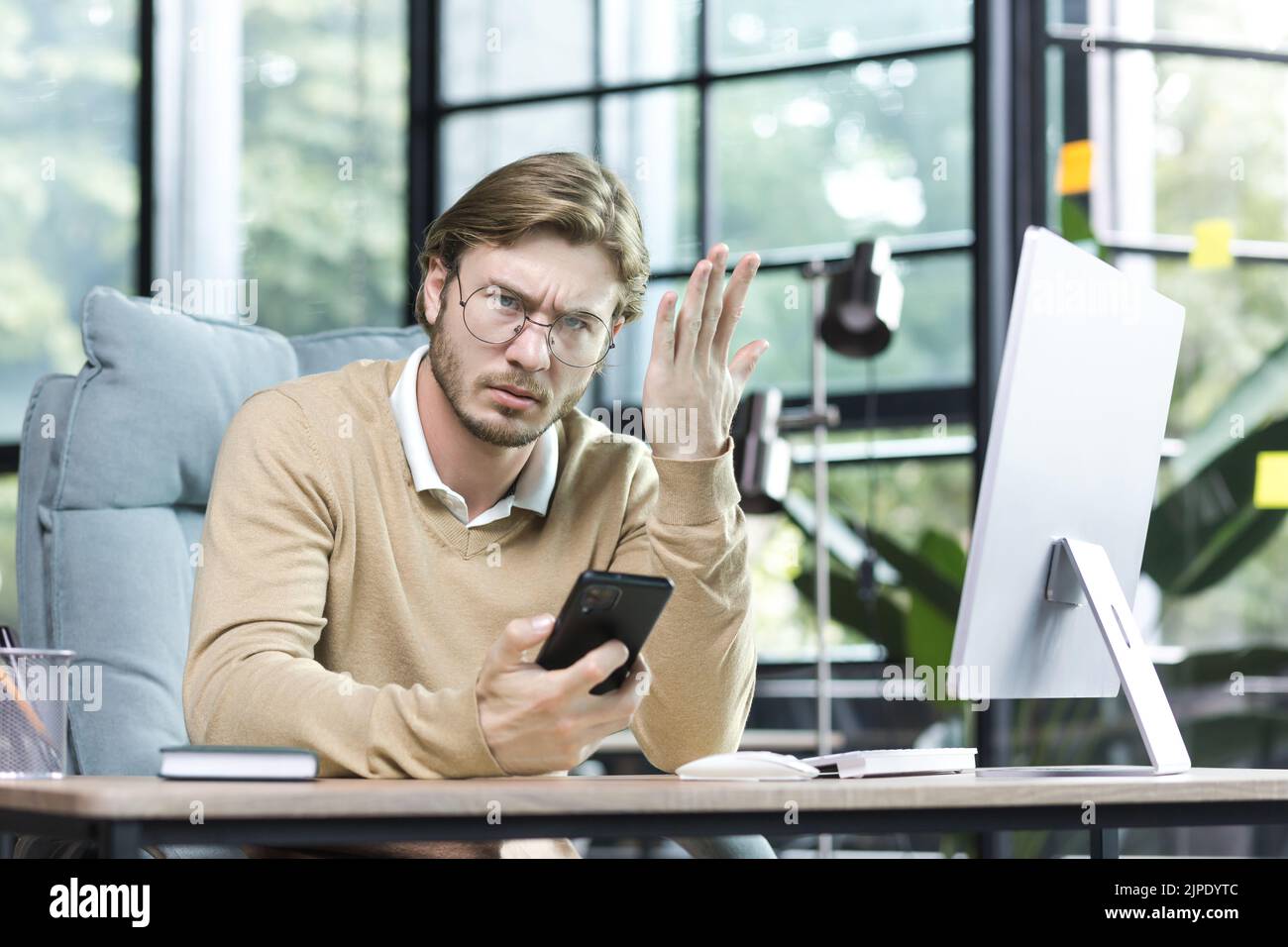 Dissatisfied businessman freelancer in glasses upset looking at camera ...