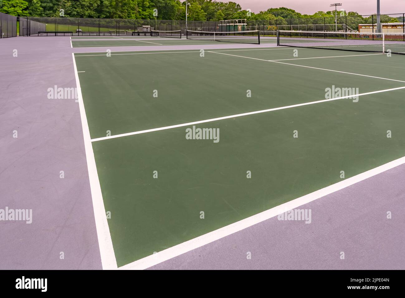 New outdoor green tennis courts with white lines and gray out of bounds ...