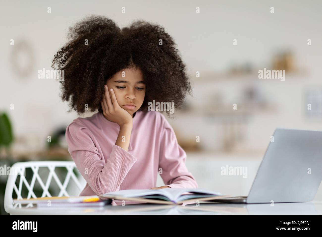 Bored african american kid suffering while doing homework Stock Photo ...
