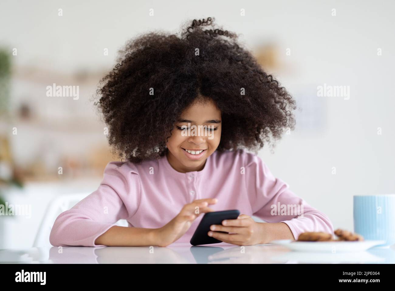 Cool african american child using cell phone at home Stock Photo - Alamy