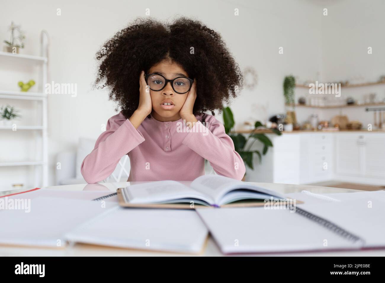 Overwhelmed african american school girl doing homework Stock Photo - Alamy