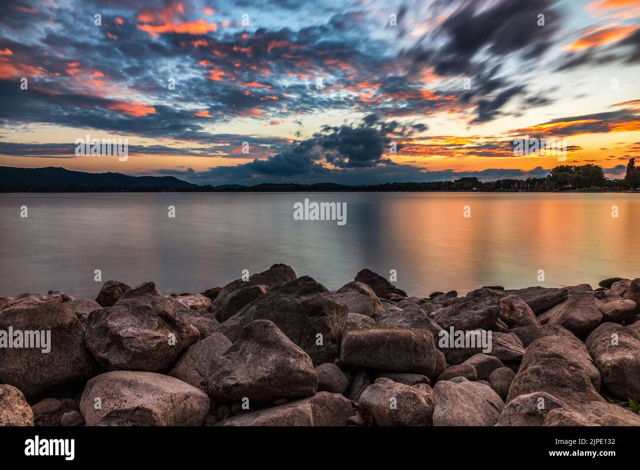 Stones on the lake shore Sunset Lake Constance with clouds in the sky ...