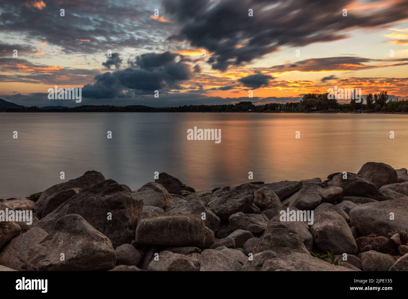 Stones on the lake shore Sunset Lake Constance with clouds in the sky ...