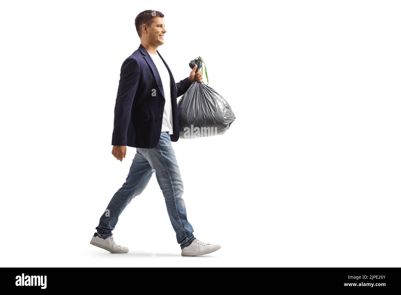 Full length profile shot of a man walking and carrying a plastic waste ...