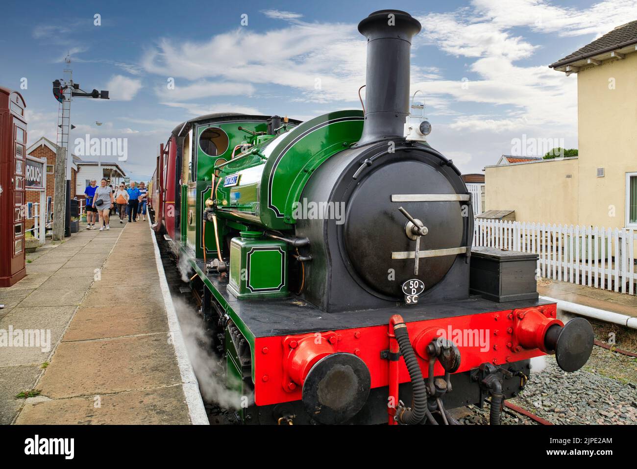 People disembarking from steam train pulled by tank engine at railway ...