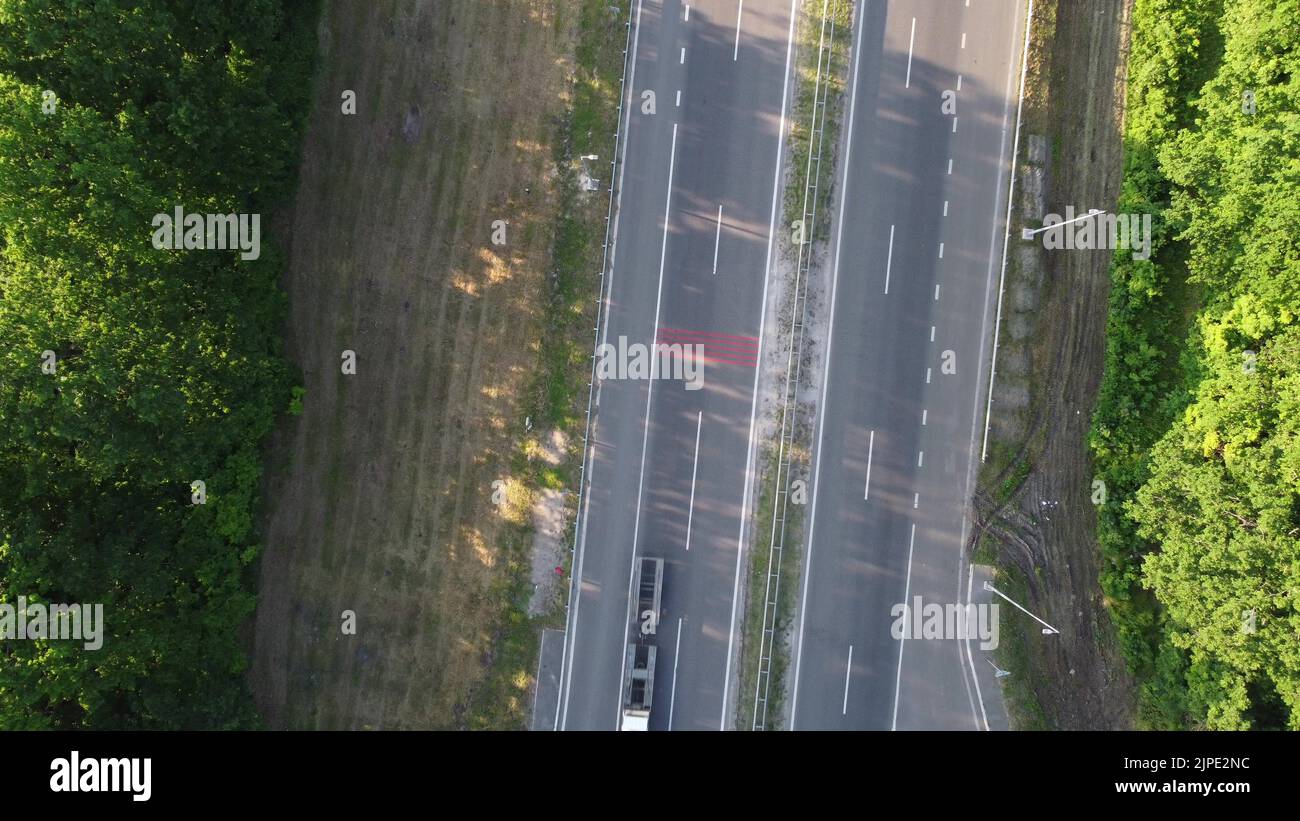 Aerial view on highway road through green fields on a summer sunny day ...