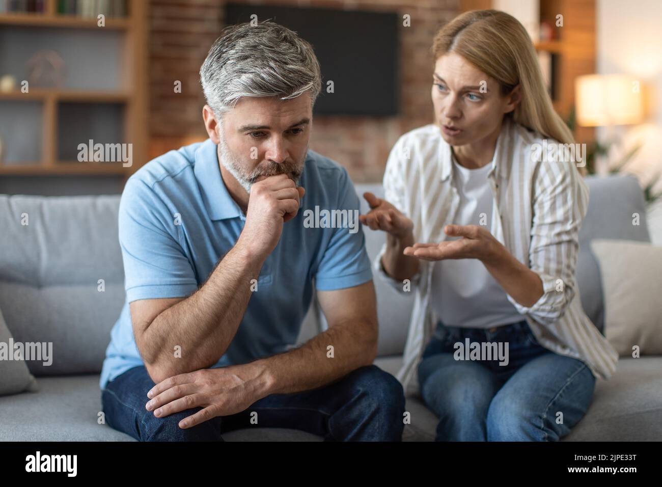 Sad upset adult caucasian wife yelling at husband, gesticulates in ...