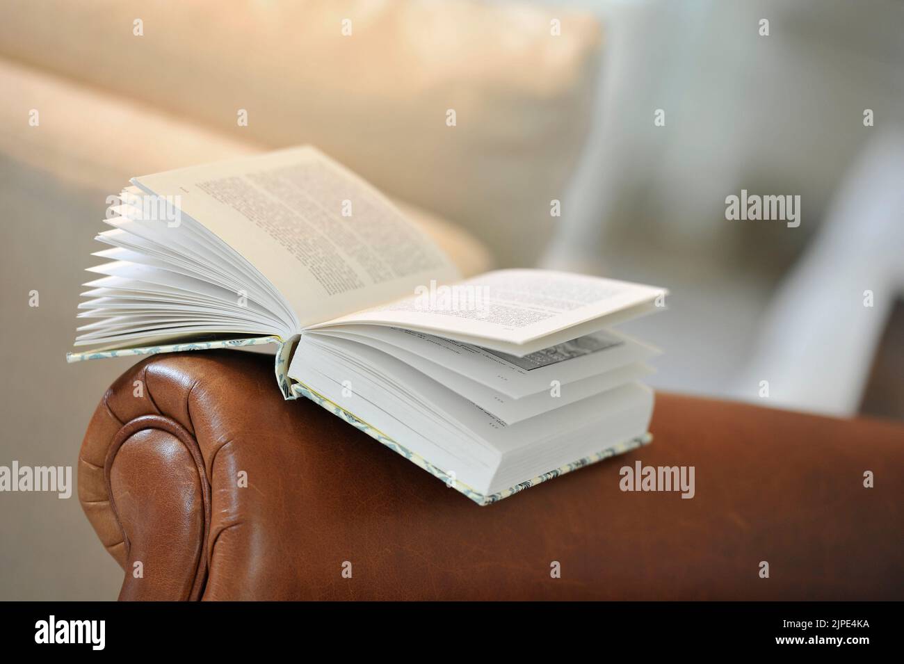 Paperback Books on the arm of a chair Stock Photo - Alamy