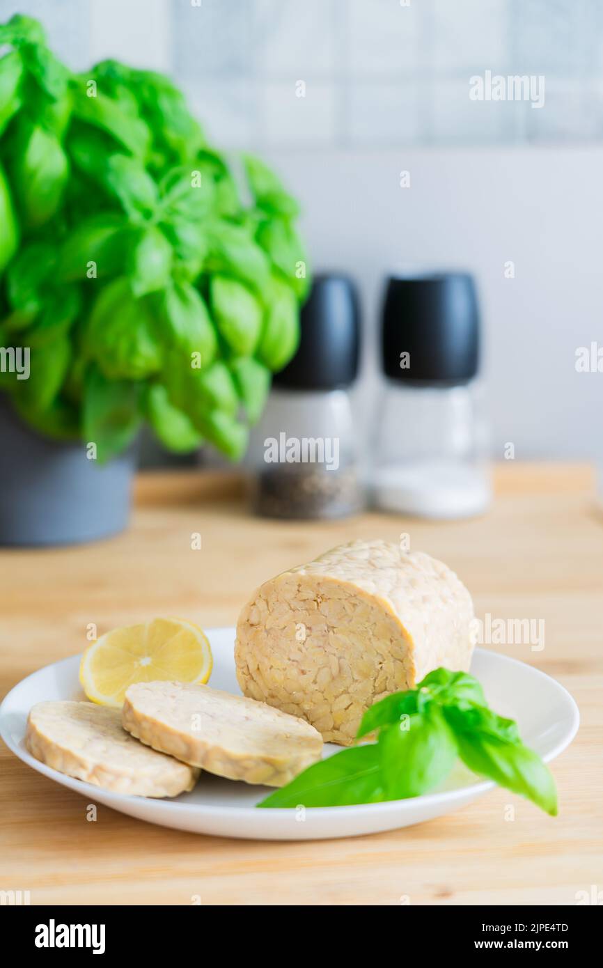 Raw Tempeh or Tempe, made of fermented soybean seeds on kitchen table ...