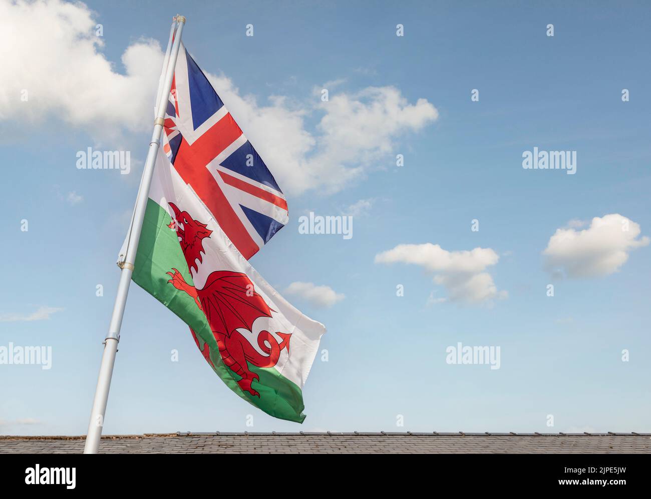 The British Union Jack and the Welsh flag fly proudly togetheragainst a ...