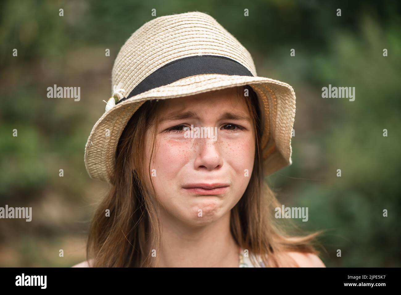 cute girl in a hat is sad and crying Stock Photo - Alamy