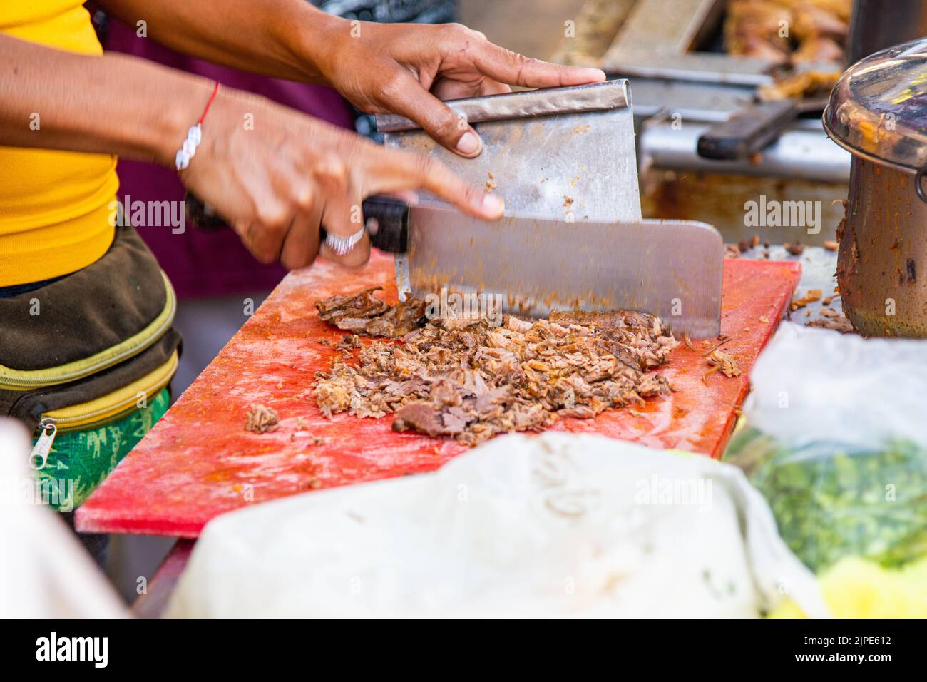 A woman chopping meat in preparation for tacos at a street food stall in Sayulita, Mexico Stock ...