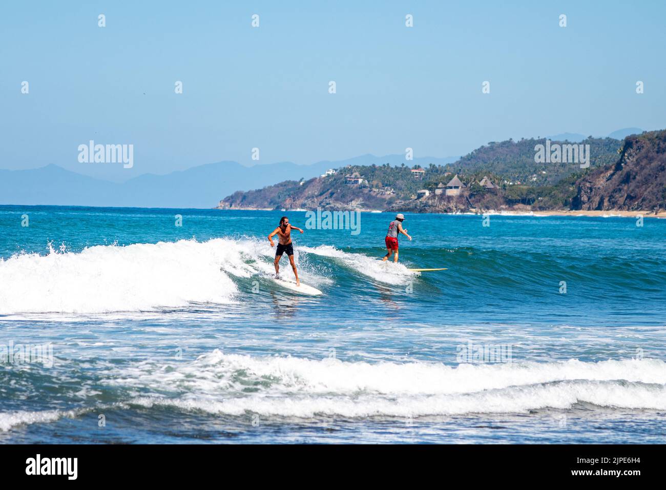 Two guys surfing on a wave on a beach in Sayulita, Mexico Stock Photo - Alamy