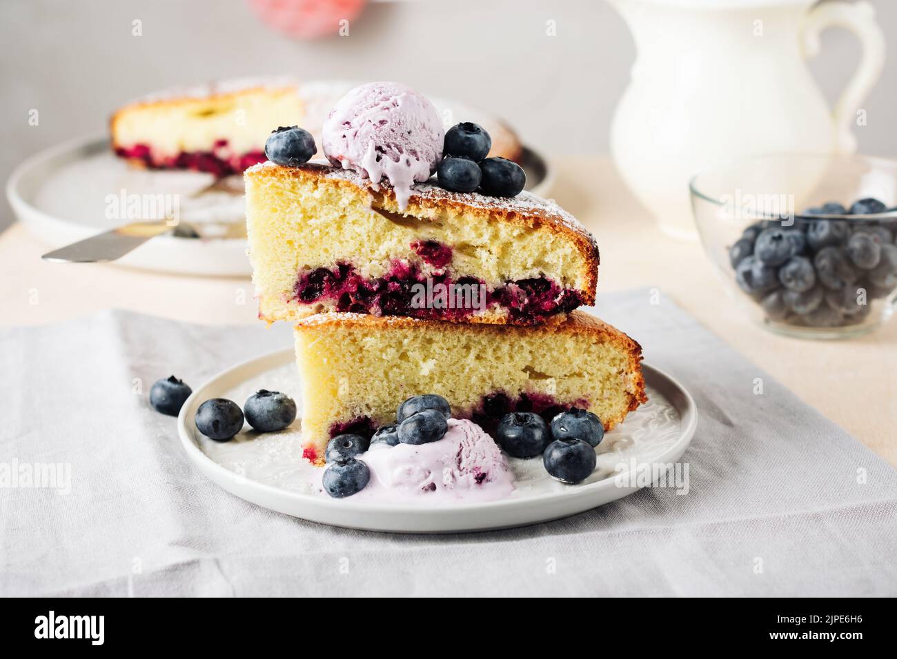 Two pieces of blueberry sponge cake with berry ice cream Stock Photo ...