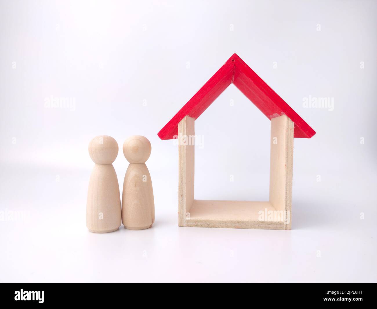 Wooden doll figures of a couple and a toy house on white background ...