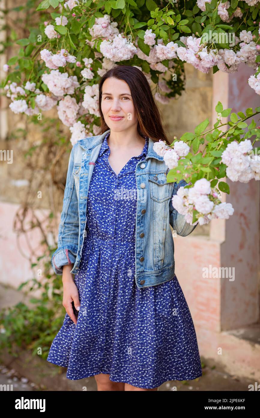 Lifestyle portrait of young stylish woman staying on the street in old ...