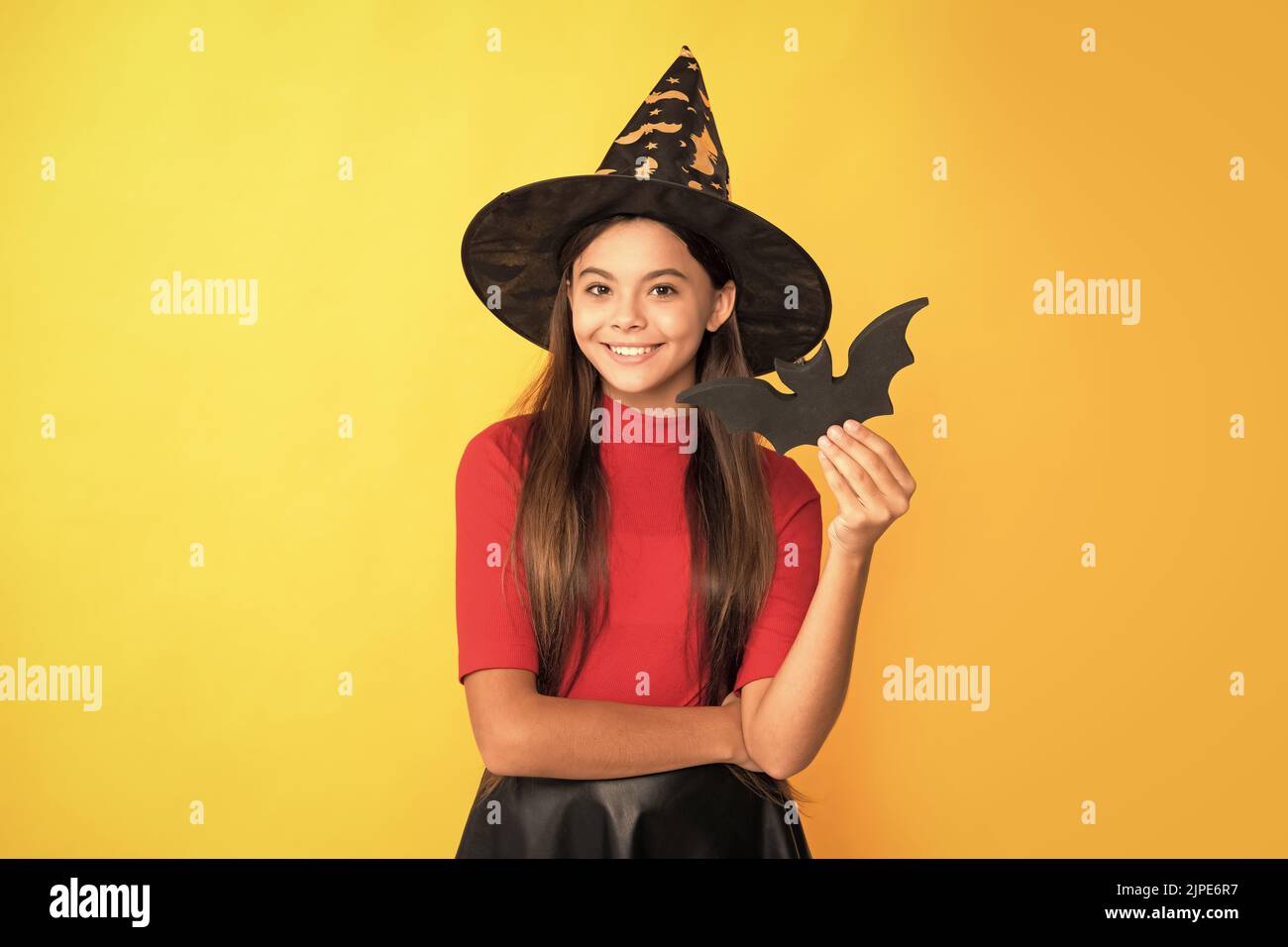 smiling kid with bat wearing witch hat on yellow background, halloween ...