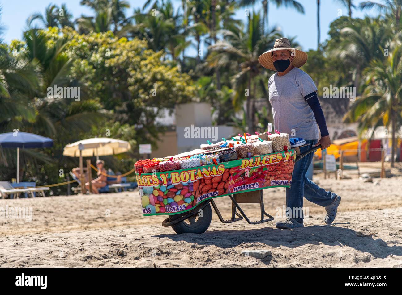 A man pushing a cart selling sweets and snacks on a beach in Sayulita ...