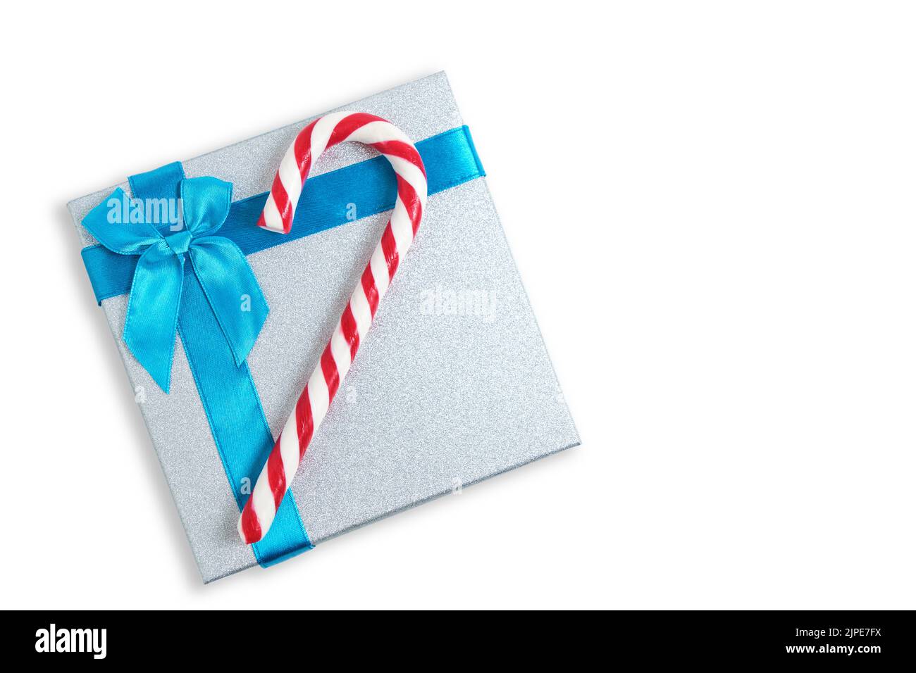 Christmas gift box with blue bow and a red and white candy in form cane ...