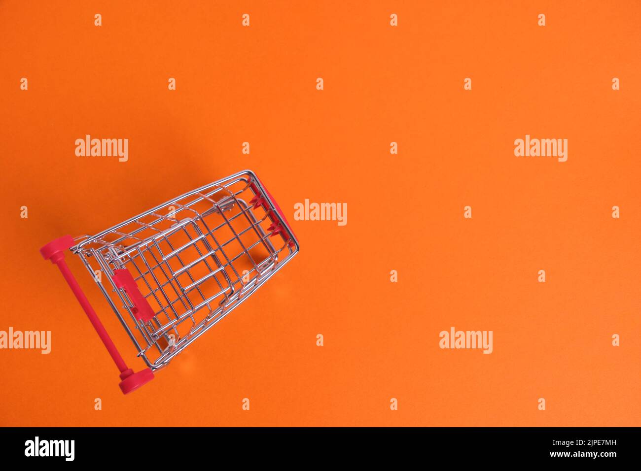 Shopping cart orange background.Concept of purchase and budget Stock ...