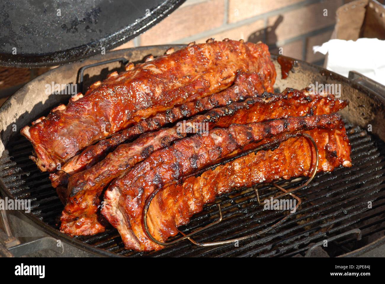 Grilling racks of ribs on an outdoor BBQ Stock Photo - Alamy