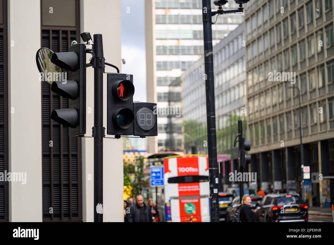 LONDON - May 20, 2022: Pedestrian crossing traffic lights above a busy ...