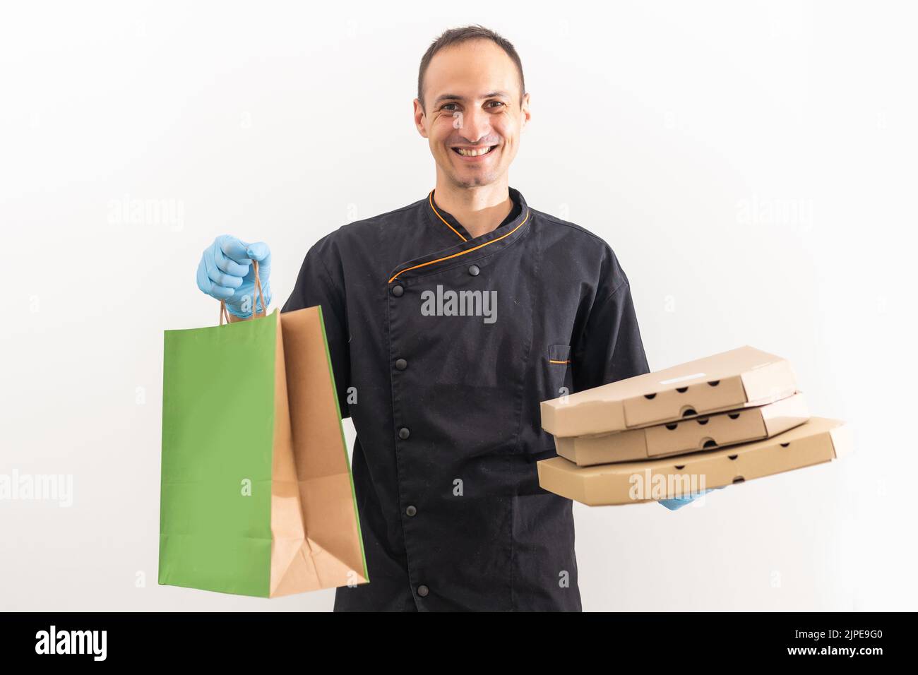 A chef in uniform offering you a pizza box. Smiling at camera Stock ...