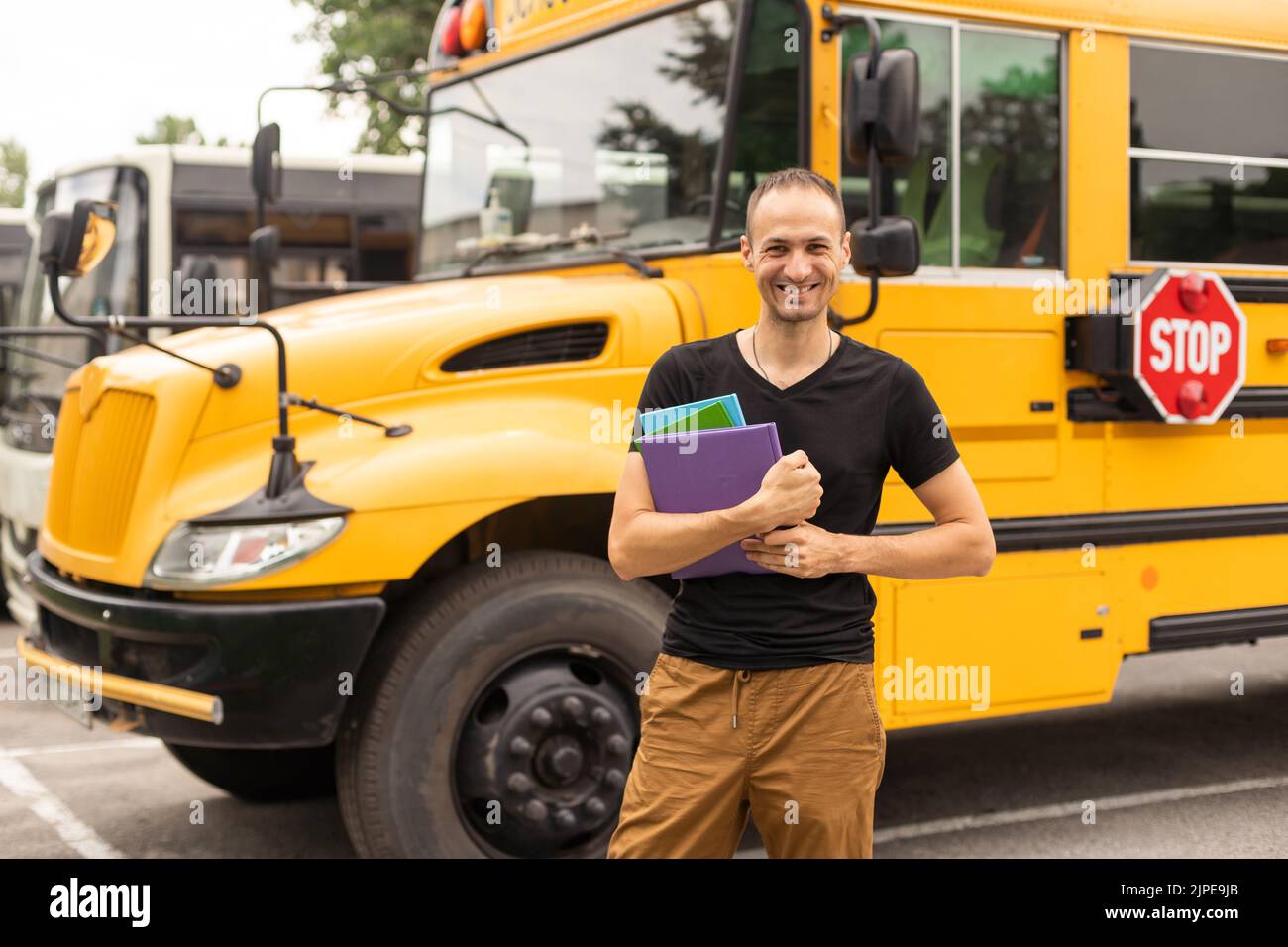 Portrait of male teacher near the school bus Stock Photo - Alamy