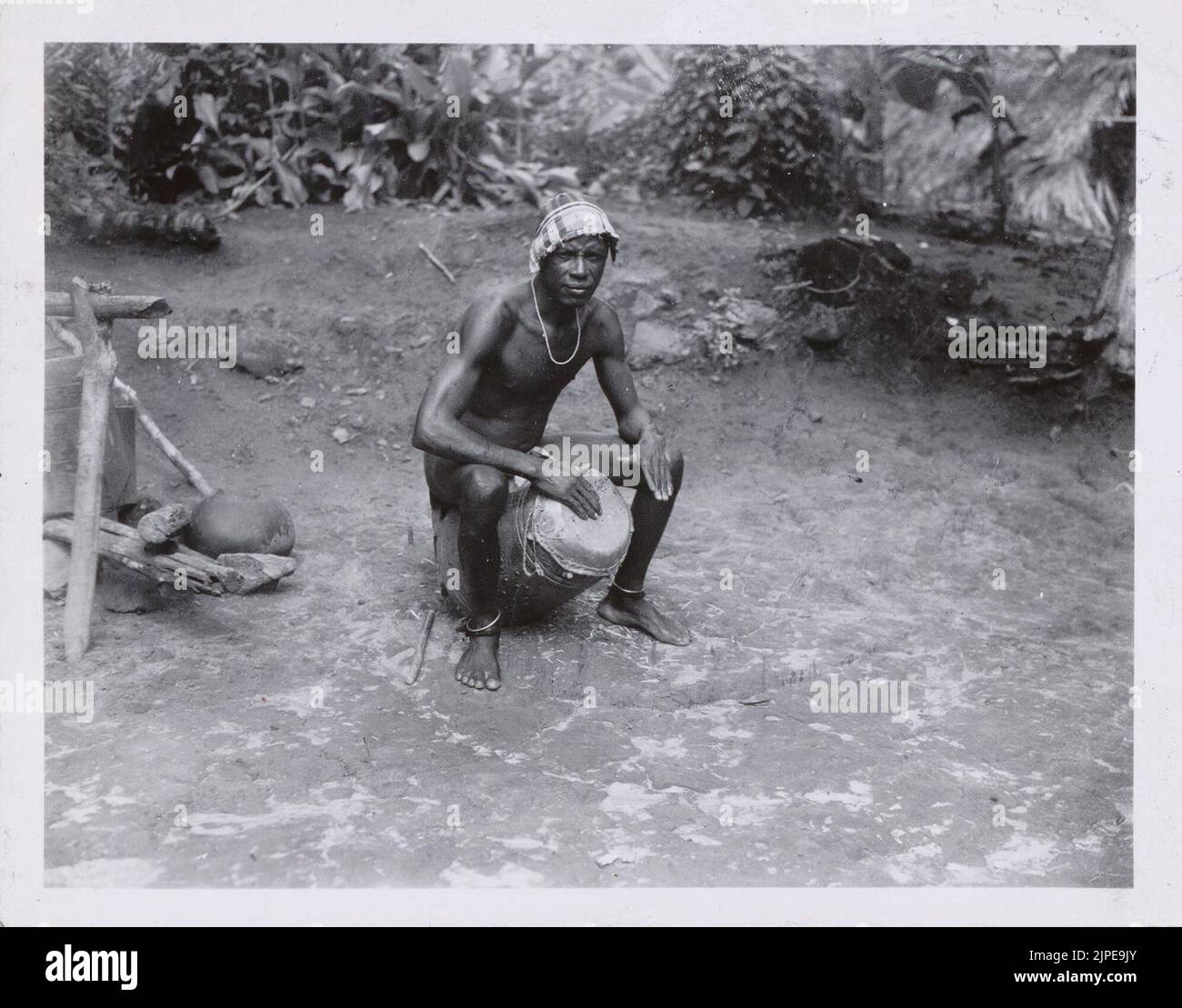 Black and white photograph of a Maroon man sitting in a village ...