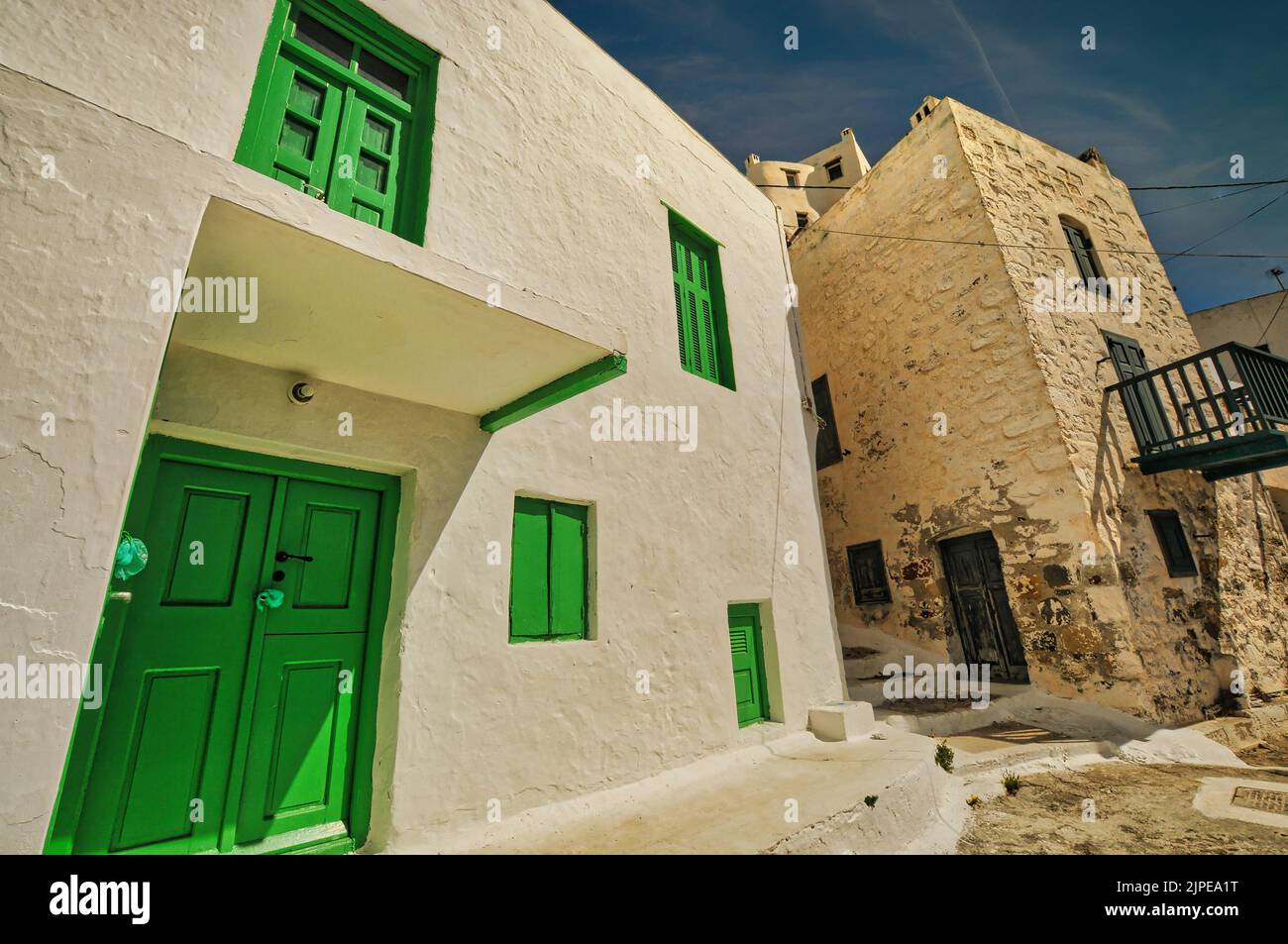 A whitewashed building with green doors and windows, in Chora village ...