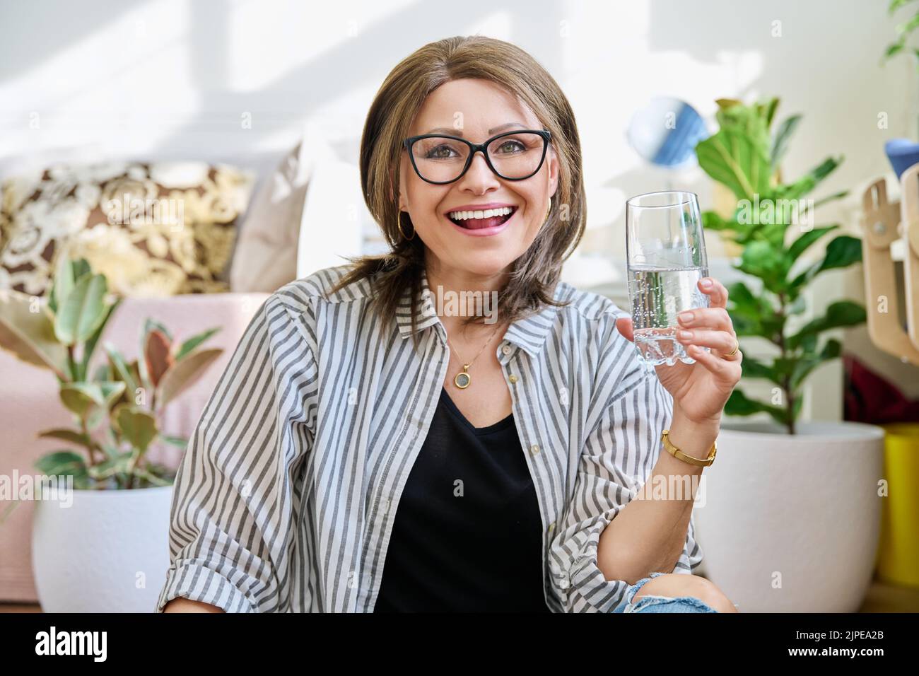Smiling mature woman with a glass of water Stock Photo - Alamy