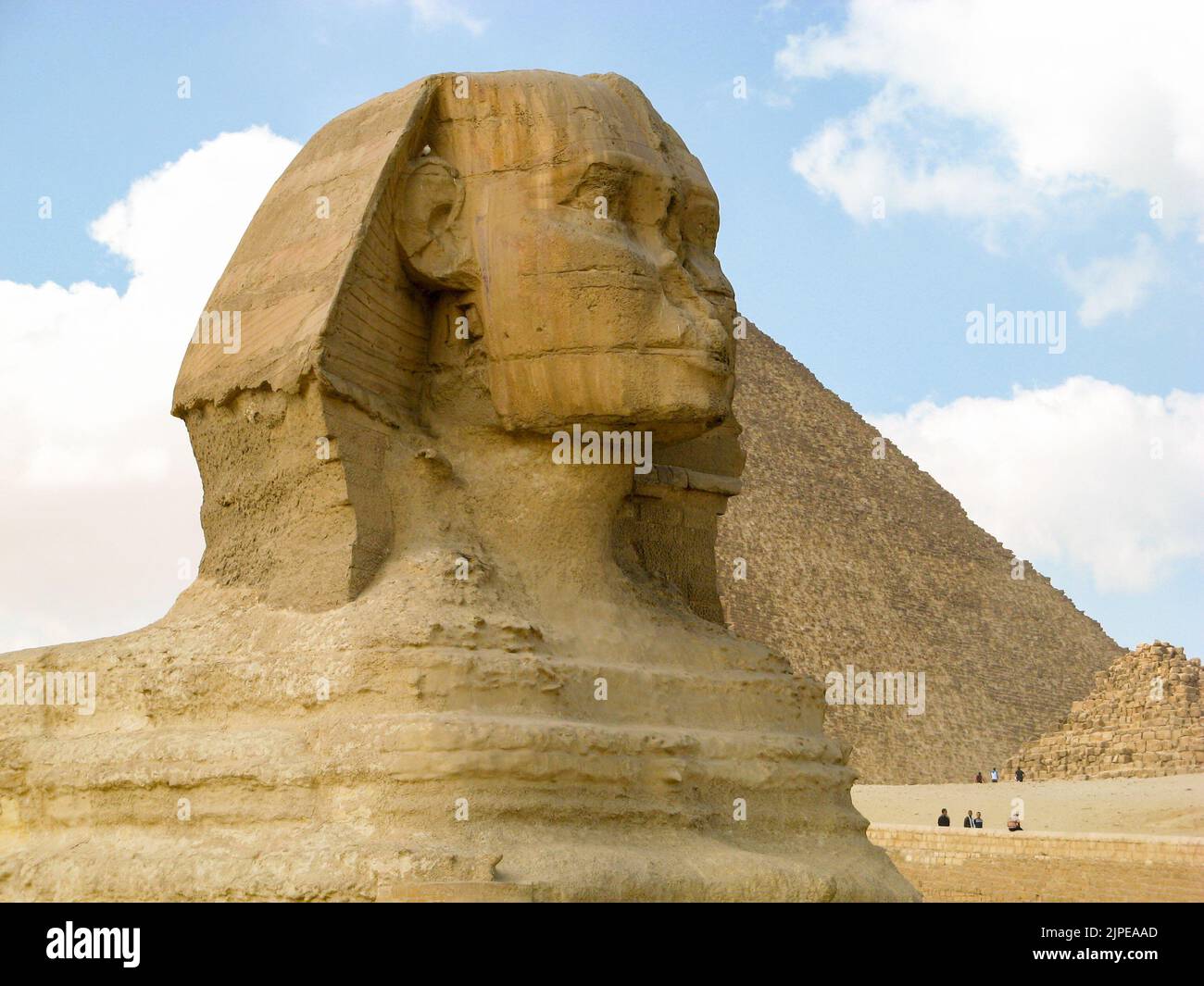 A closeup shot of the body of Sphinx in desert with the Great Pyramid ...