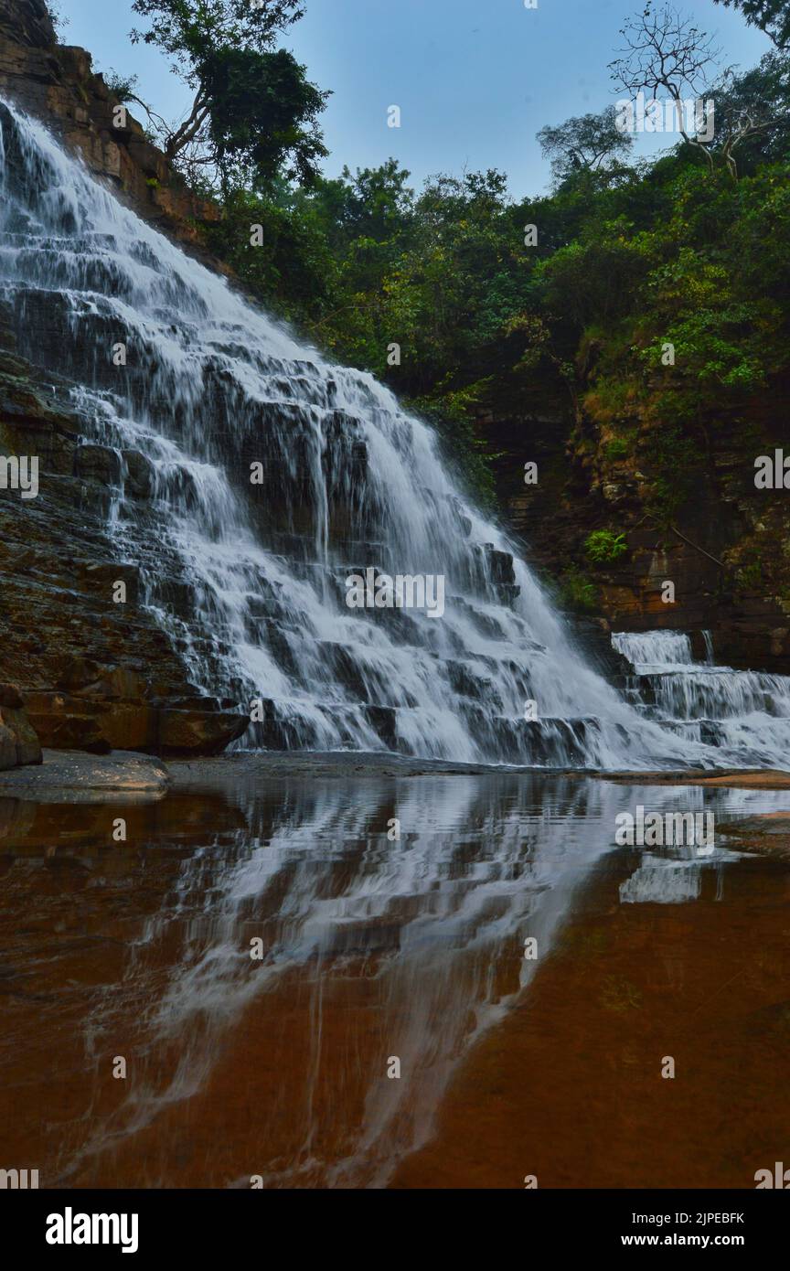 A vertical shot of a beautiful waterfall with reflection in Jagdalpur ...