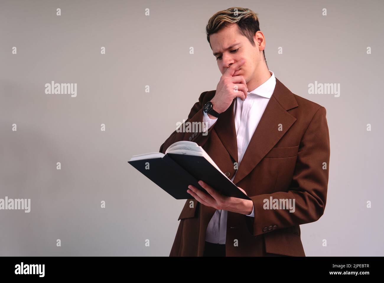 Elegant man with thoughtful expression while reading a book. Business ...