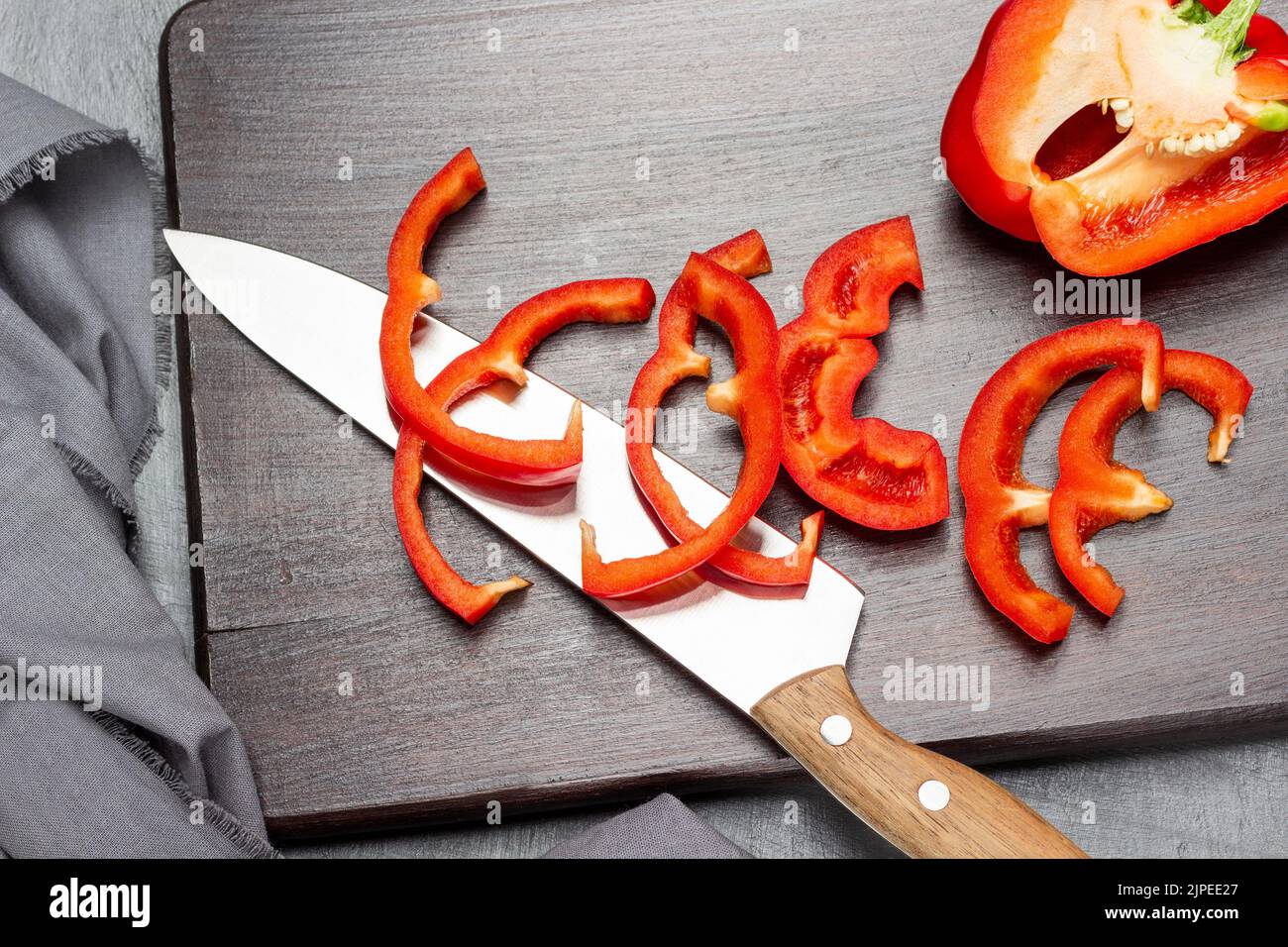Kitchen knife, chopped red pepper, and half pepper on cutting board ...