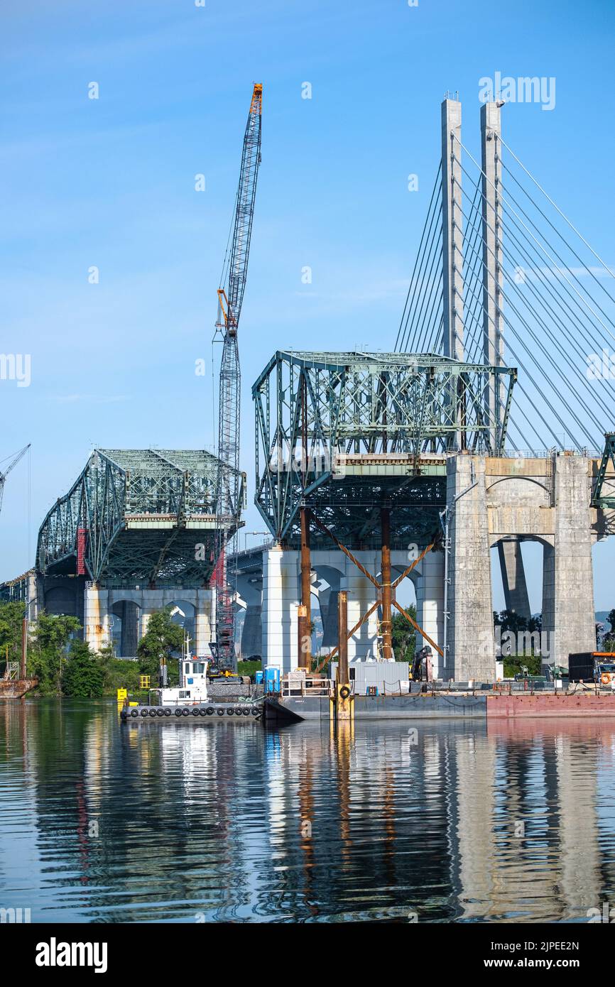 An old bridge is under demolition next to a new cable-stayed bridge ...