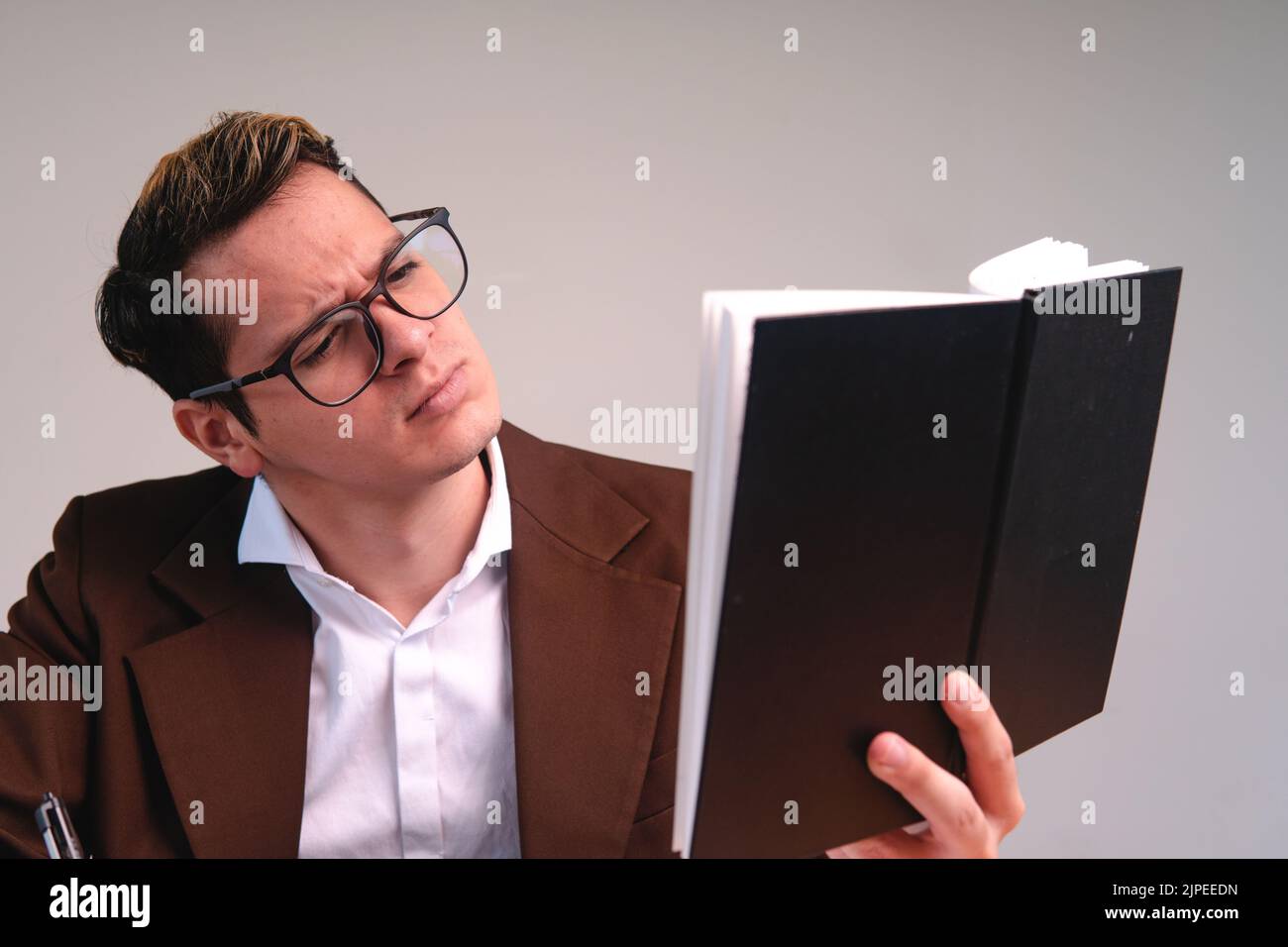 Lawyer reading a book confused. Business man in a brown suit, white ...