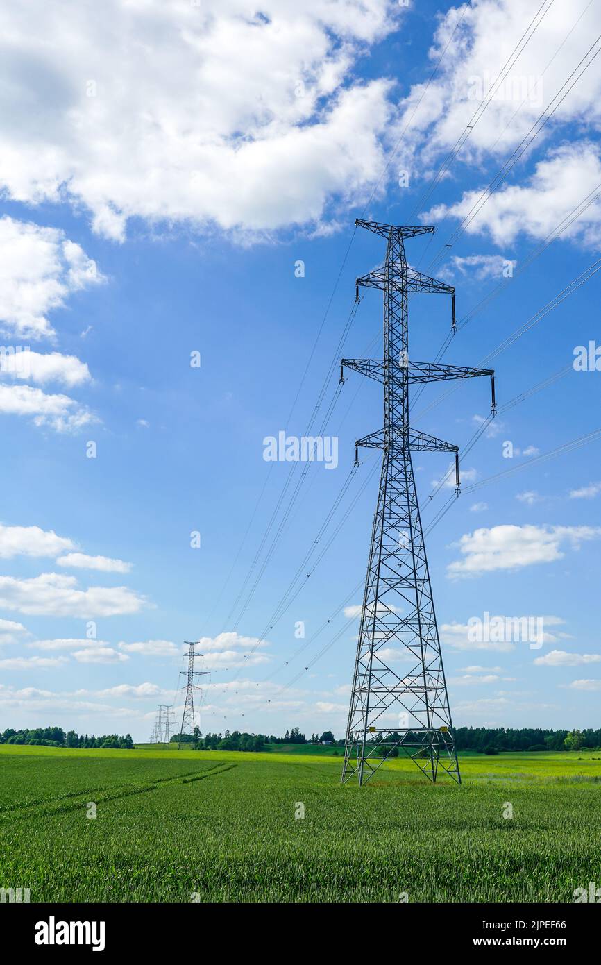 High-voltage power transmission line pylons in a cereal field on a ...