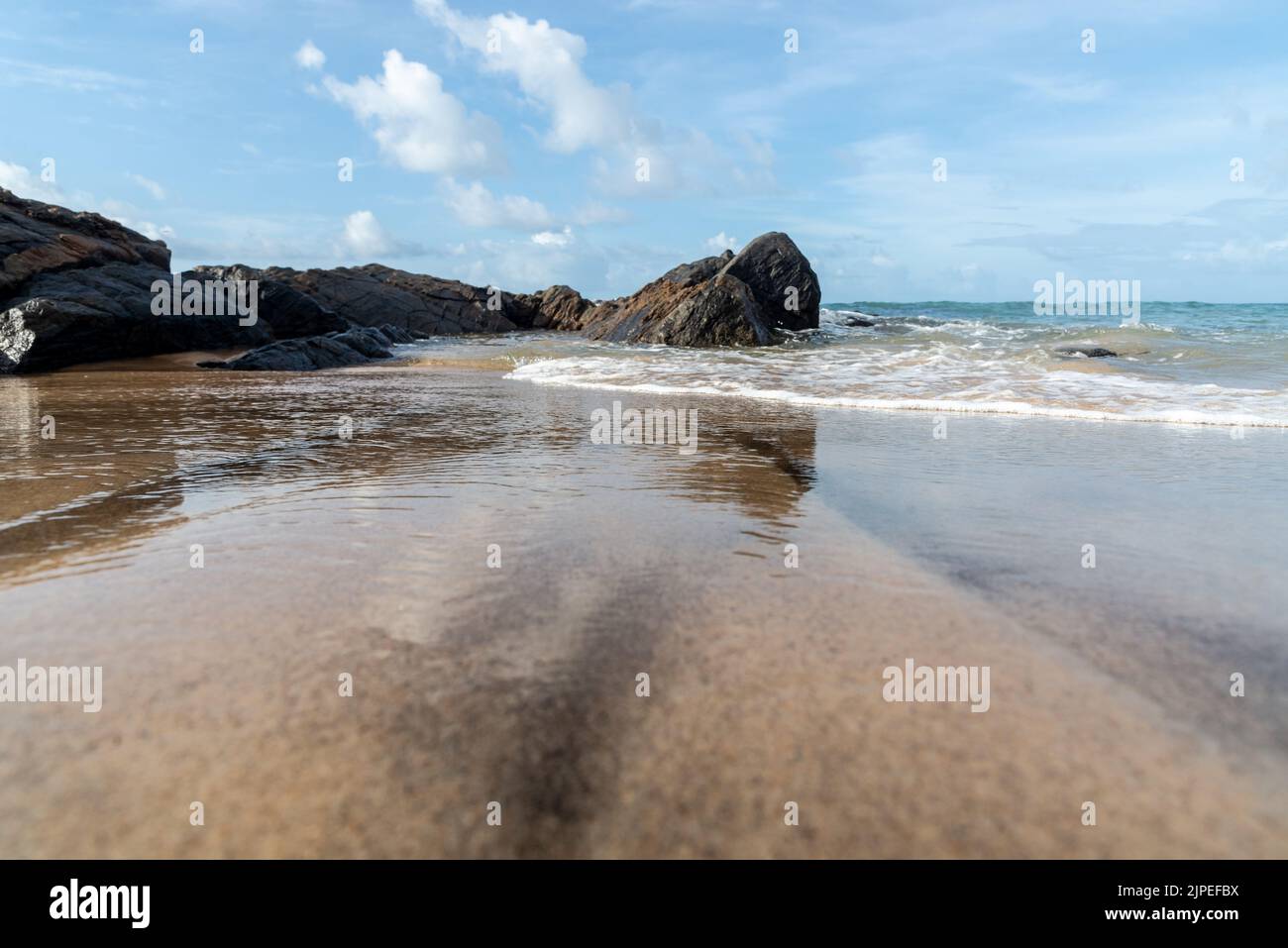 A wave breaks about a rock during a curtain on the sea. Farol da Barra ...