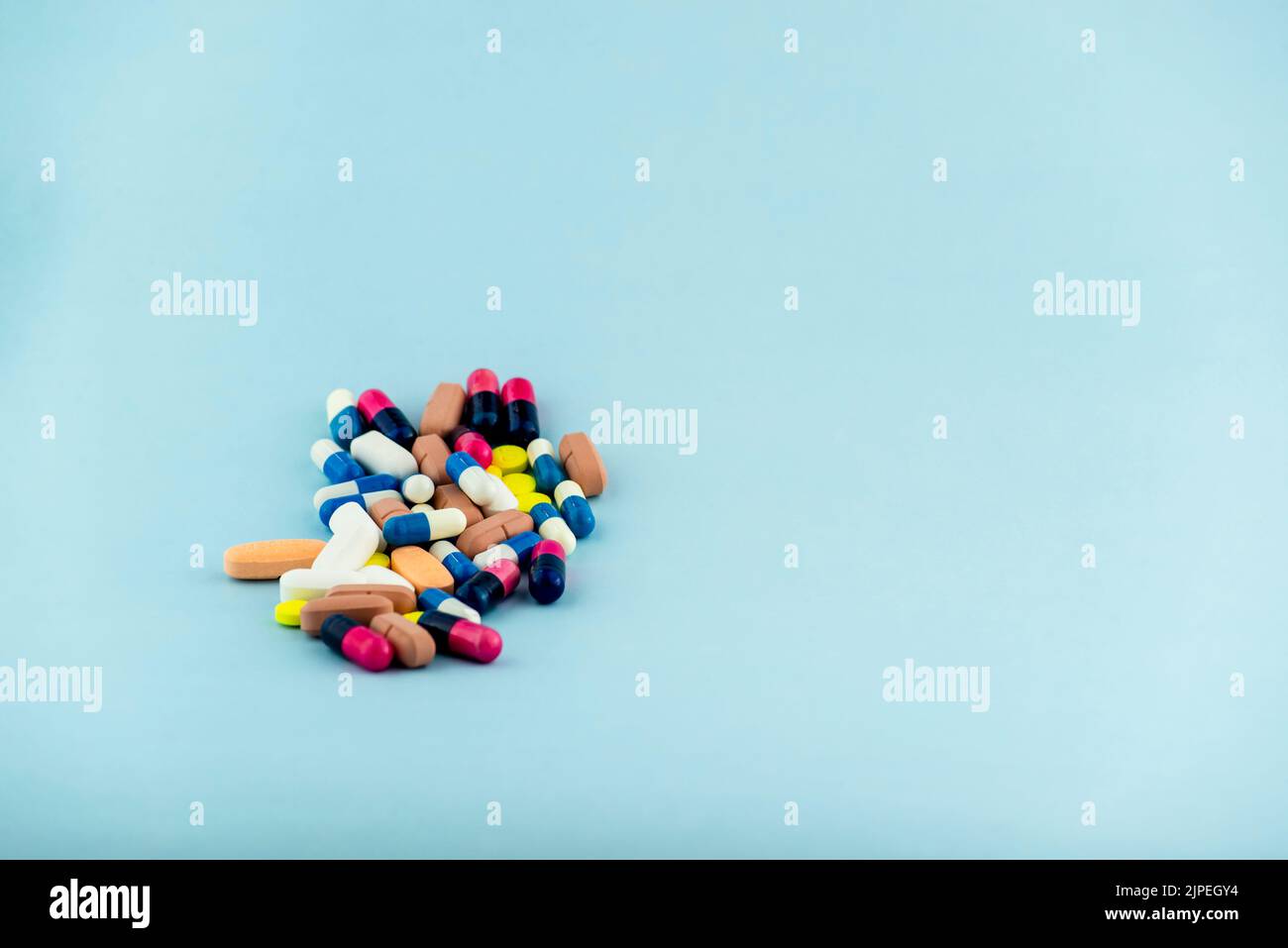 Simple pile of colorful pills. Medicines, pills stacked on blue ...