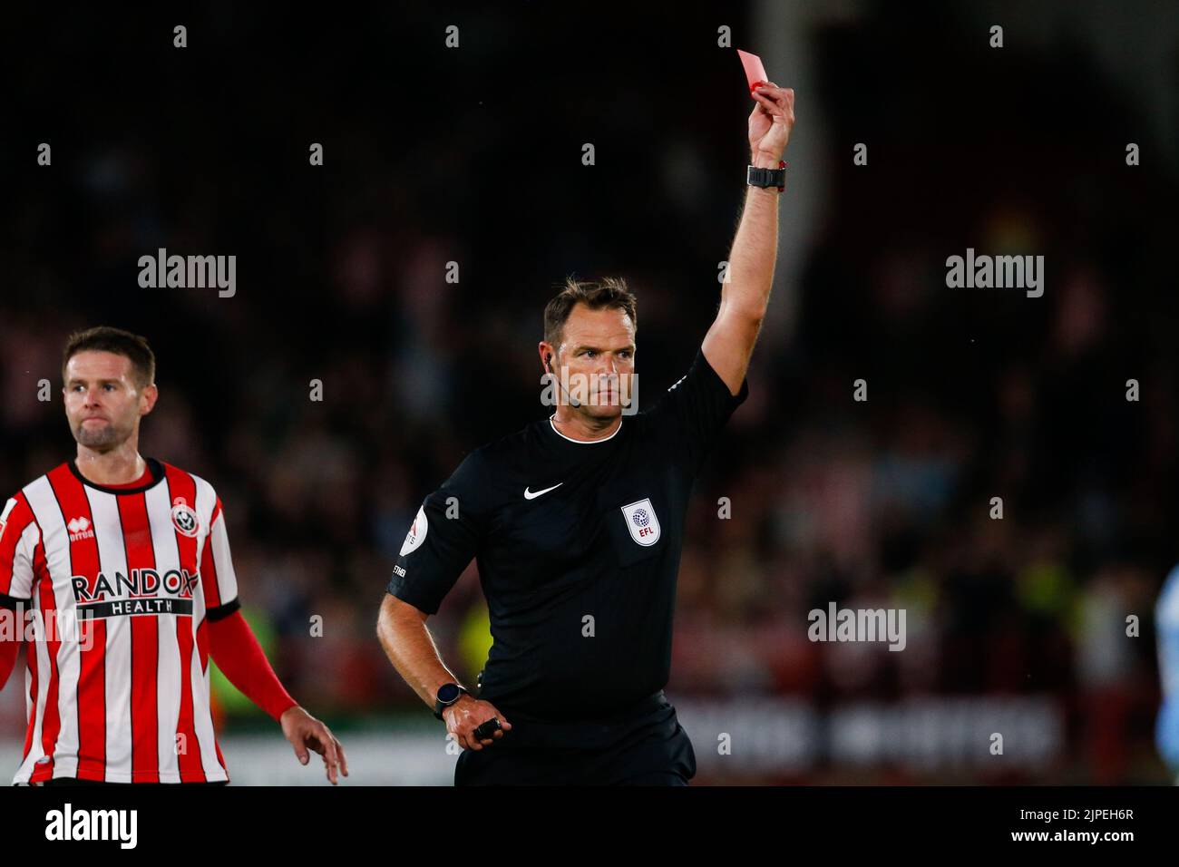 Referee James Linington issues a red card to Dan Neil #24 of Sunderland ...